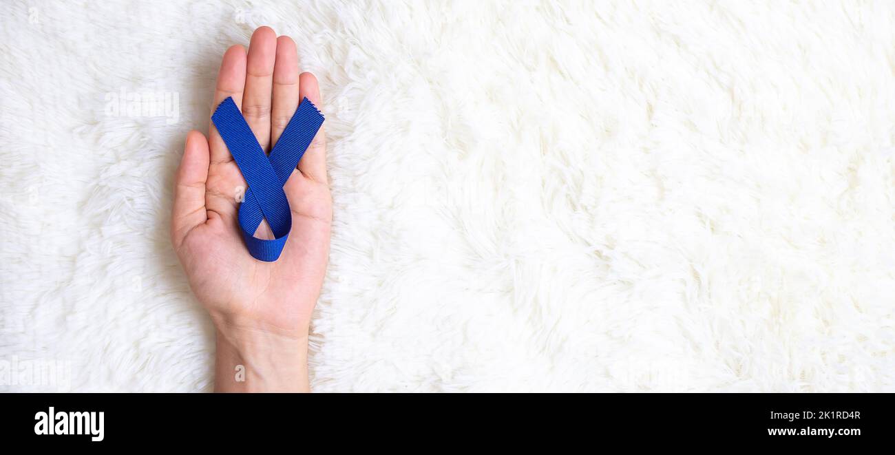 March Colorectal Cancer Awareness Month Man Holding Dark Blue Ribbon