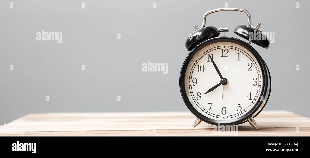 Vintage alarm clock on wooden table background and copy space for text ...
