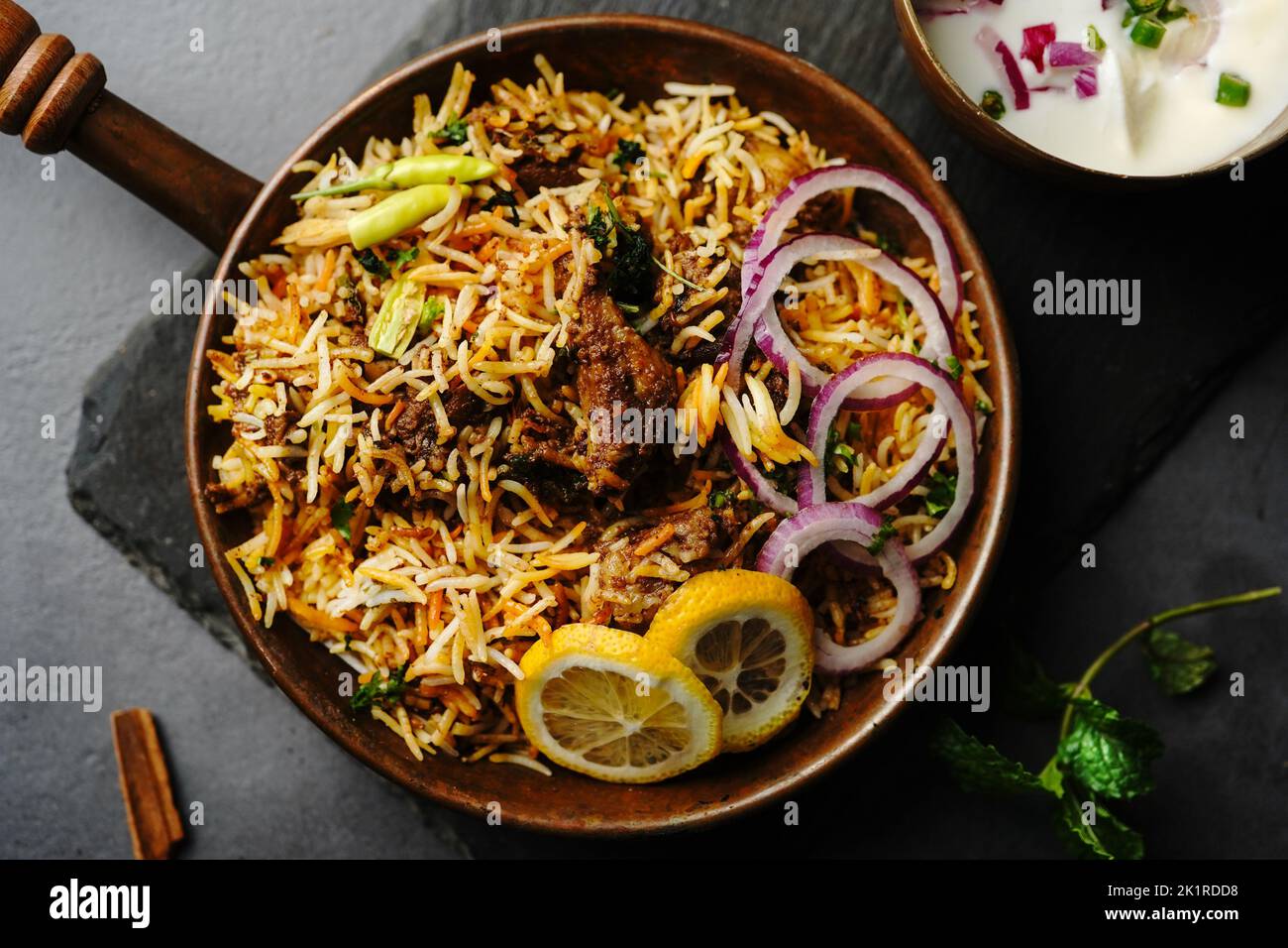 Hyderabadi Mutton goat biryani served with yogurt raita on moody ...