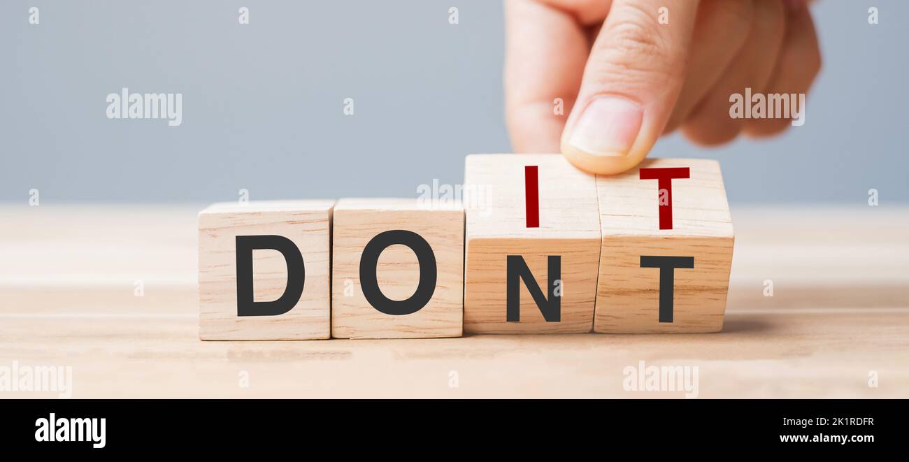 Business man hand flip block DON T to DO IT. impossible, mindset ...