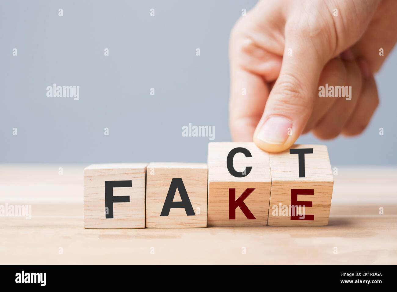 Business man hand holding wooden cube with flip over block FAKE to FACT ...