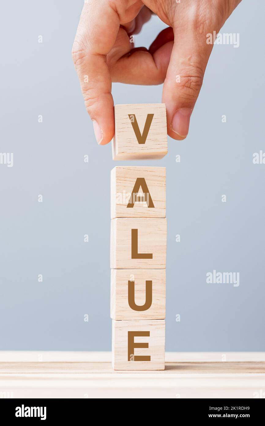 Business man hand holding wooden cube block with Value business word on ...
