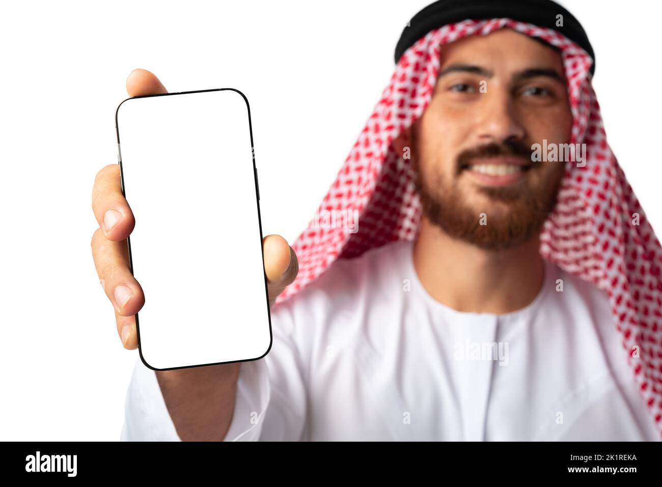 Young Arab muslim man in traditional clothes showing mobile phone ...