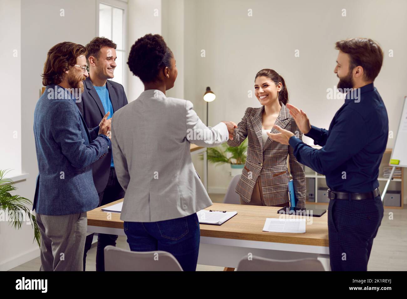 HR manager shaking hands with happy young woman after her successful ...