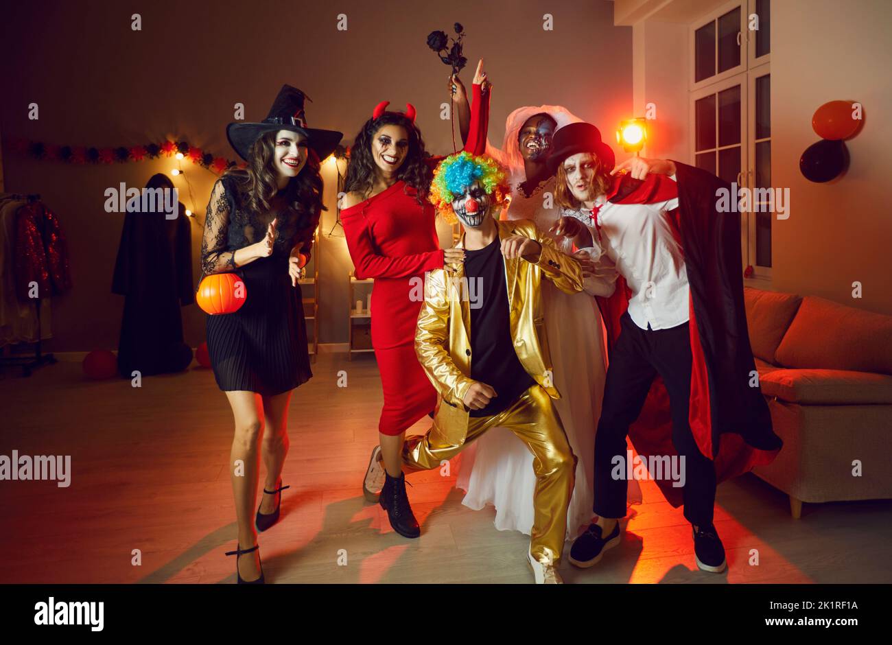 Portrait of multiracial adult friends in spooky costumes having fun at ...