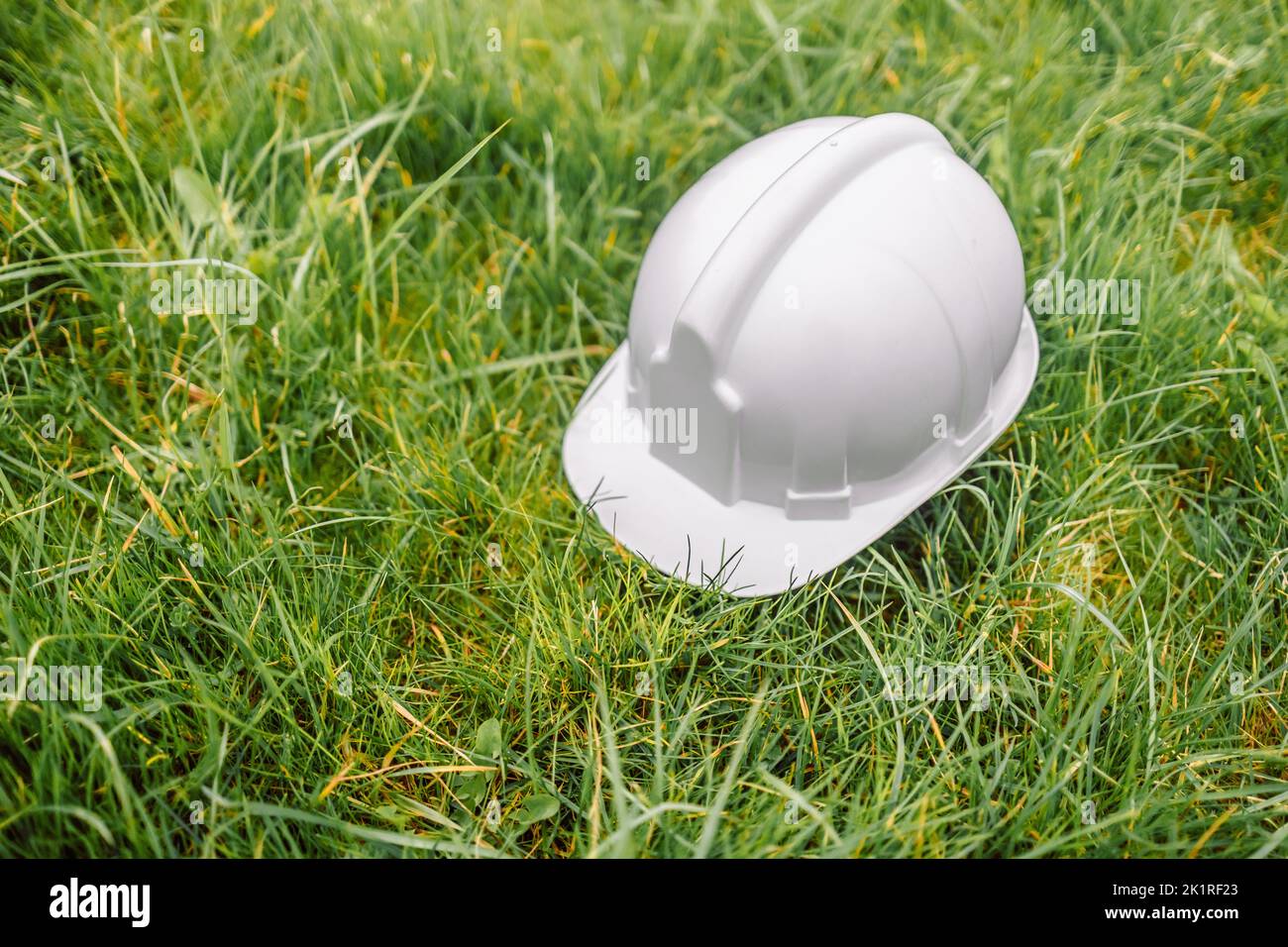 White helmet on green background, save earth engineering concept ...