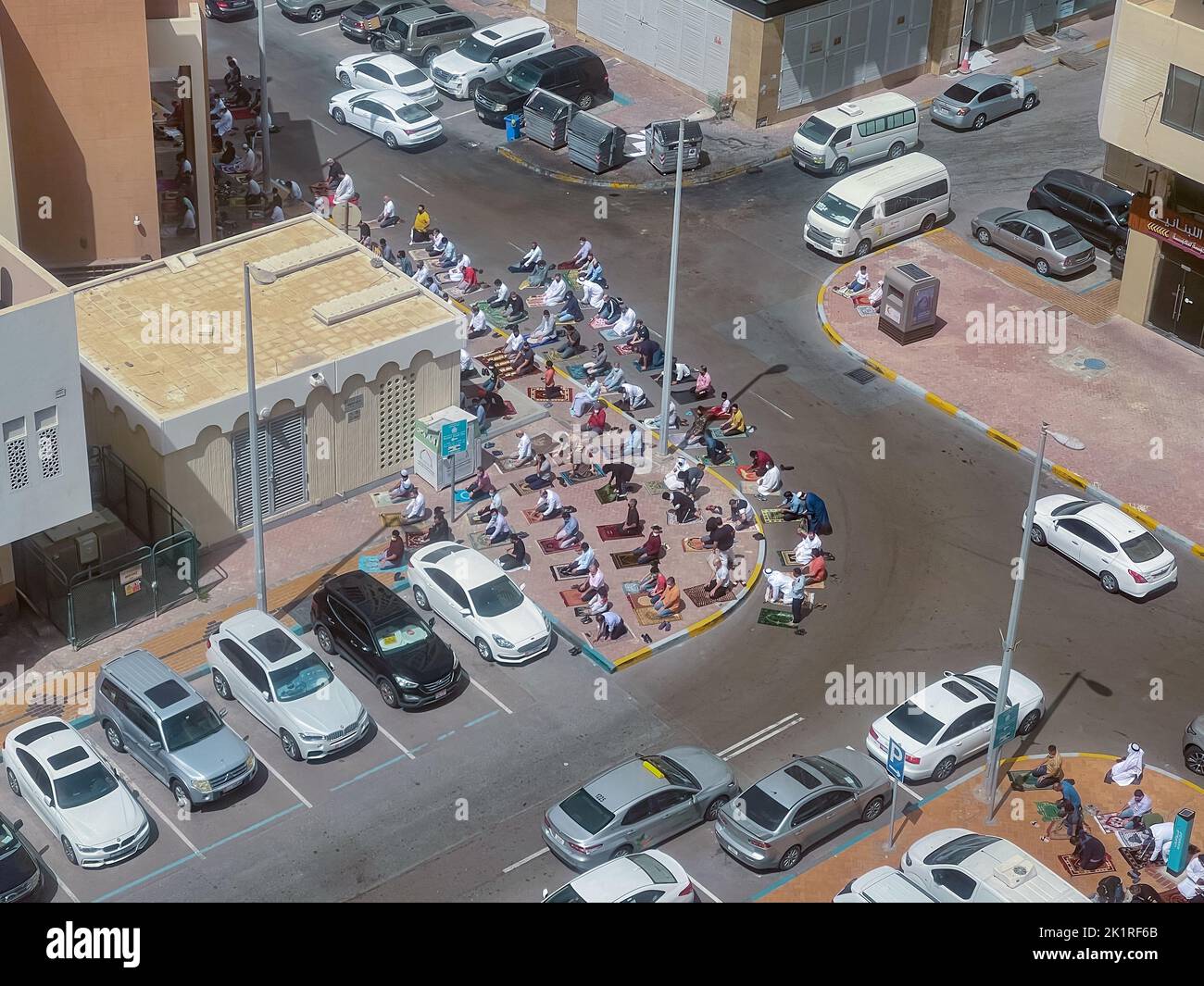 Aerial high shot of muslims praying outside a mosque due to it being ...