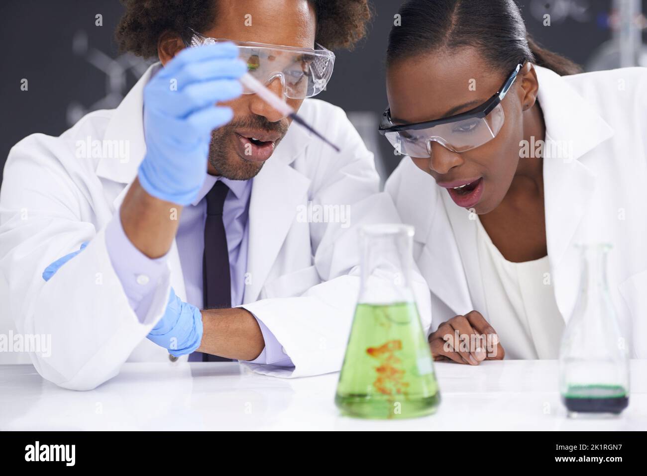 Exciting stuff, man. two scientists conducting an experiment with ...