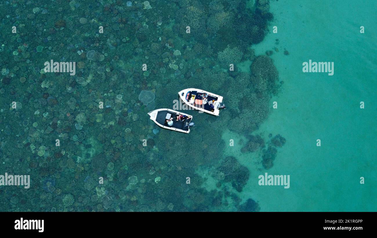 An aerial top shot of people cruising on small boats on clear water ...