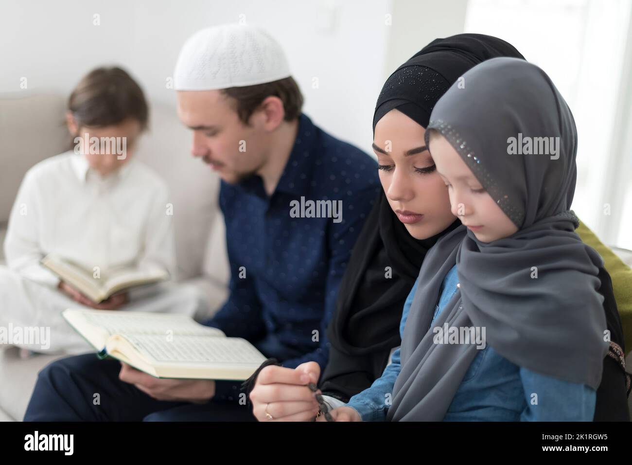 Traditional muslim family parents with children reading Quran and ...