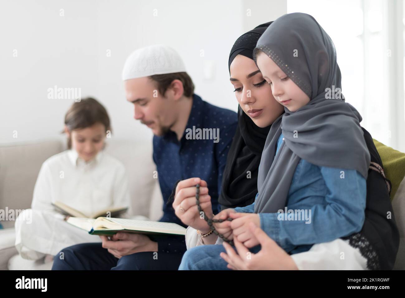Traditional muslim family parents with children reading Quran and ...