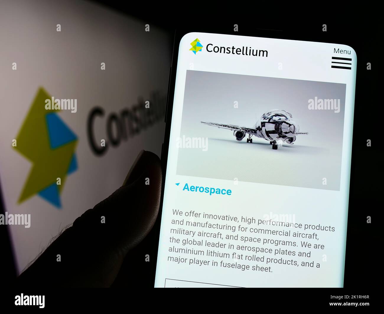 Person holding cellphone with webpage of French aluminium company ...