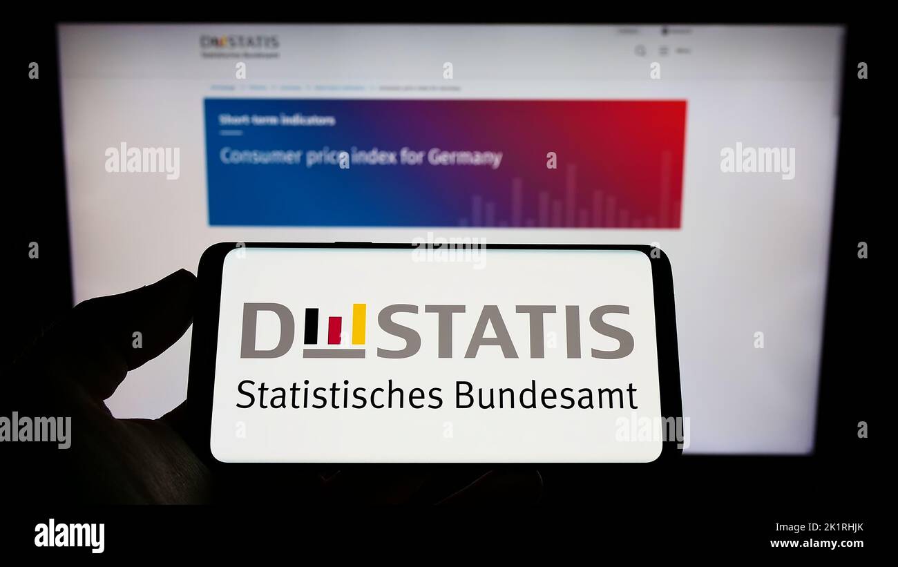 Person holding cellphone with logo of German Statistisches Bundesamt ...