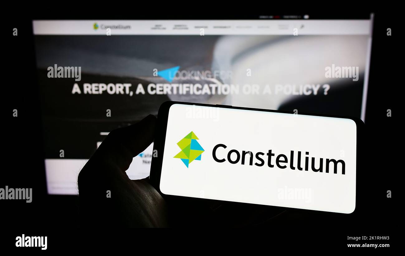 Person holding mobile phone with logo of French aluminium company ...