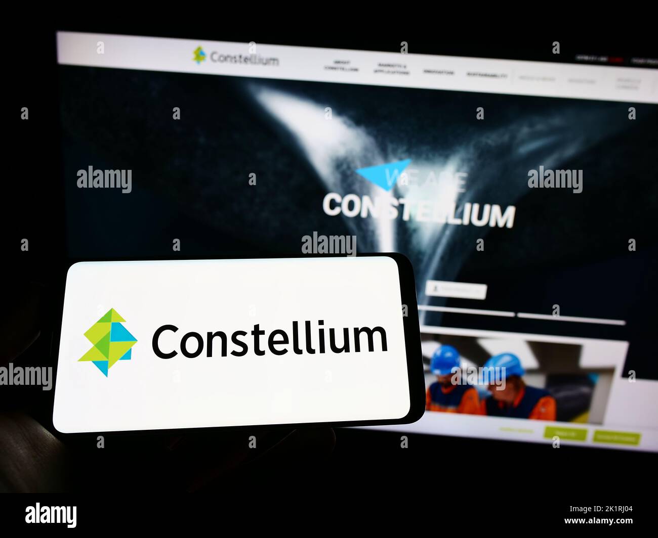 Person holding cellphone with logo of French aluminium company ...