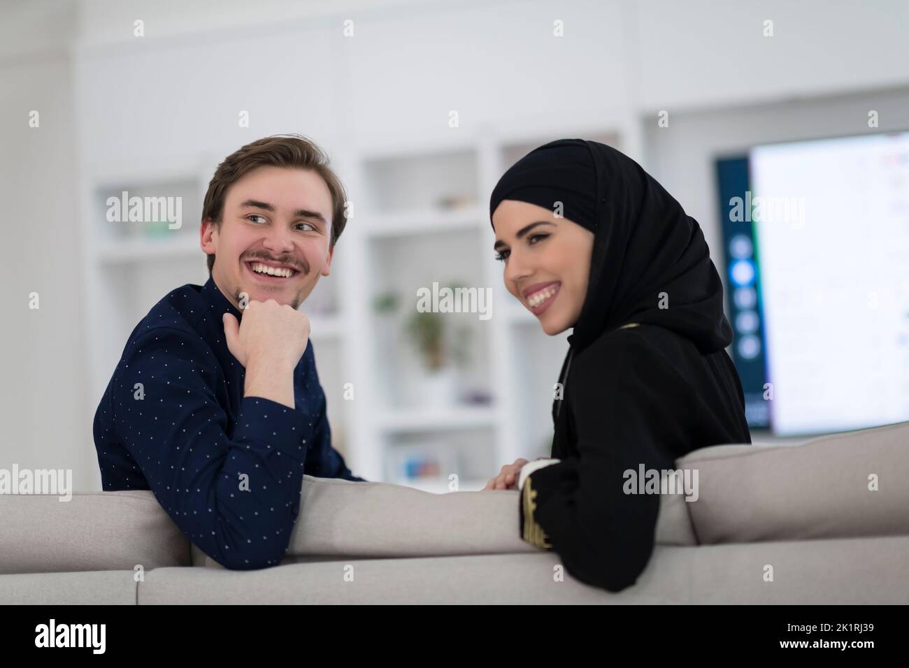 Young muslim couple woman wearing islamic hijab clothes sitting on sofa ...