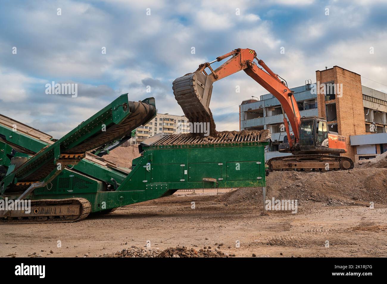 Excavator loads soil in mobile crushing and sorting complex Stock Photo ...