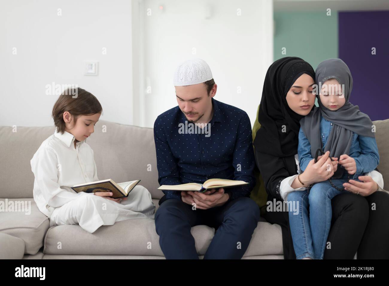 Traditional muslim family parents with children reading Quran and ...