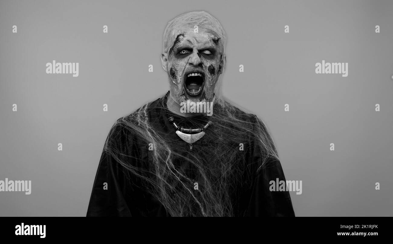 Sinister man in carnival costume of Halloween crazy zombie with bloody ...