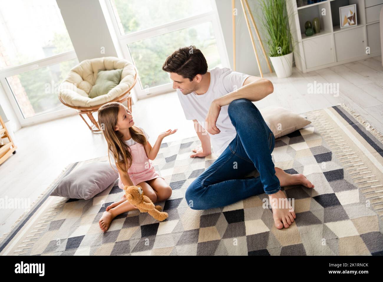Full size photo of two cheerful peaceful people sit floor communicate ...