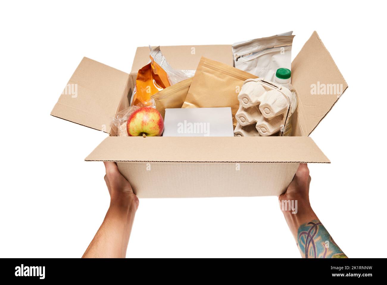 Unrecognizable man holding donation carton box with different products ...