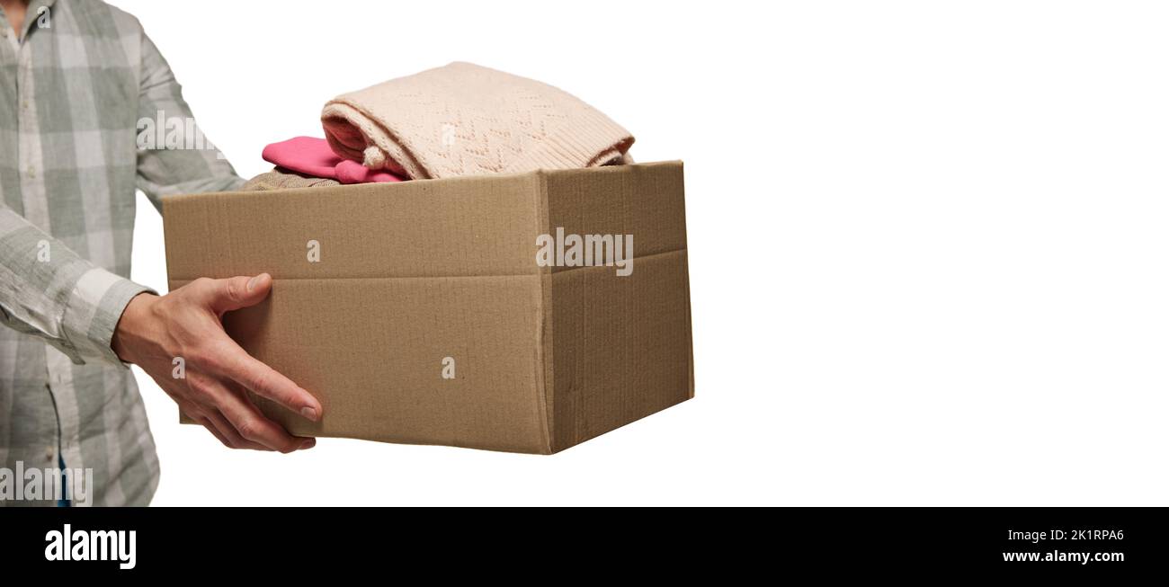 Unrecognizable man holding donation carton box with different products ...