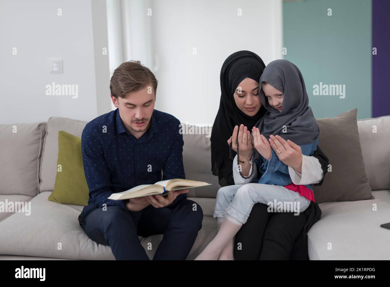 Traditional muslim family parents with children reading Quran and ...