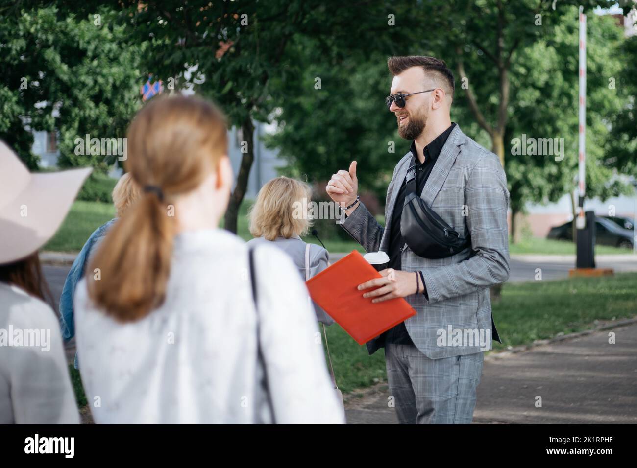 man is a tour guide inviting a group of tourists on a tour Stock Photo ...