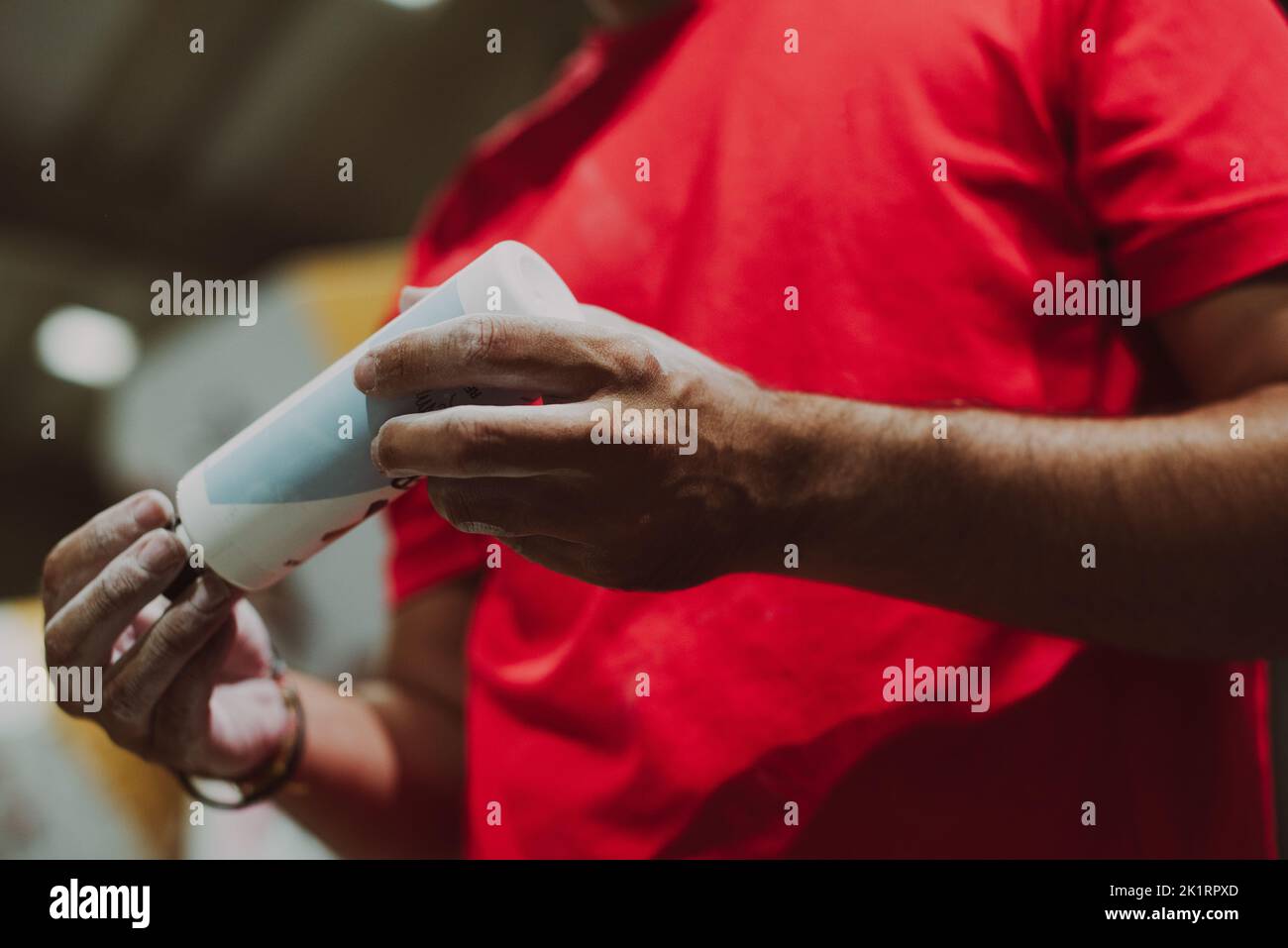 Hands pouring liquid magnesium from a bottle to practice climbing wall ...