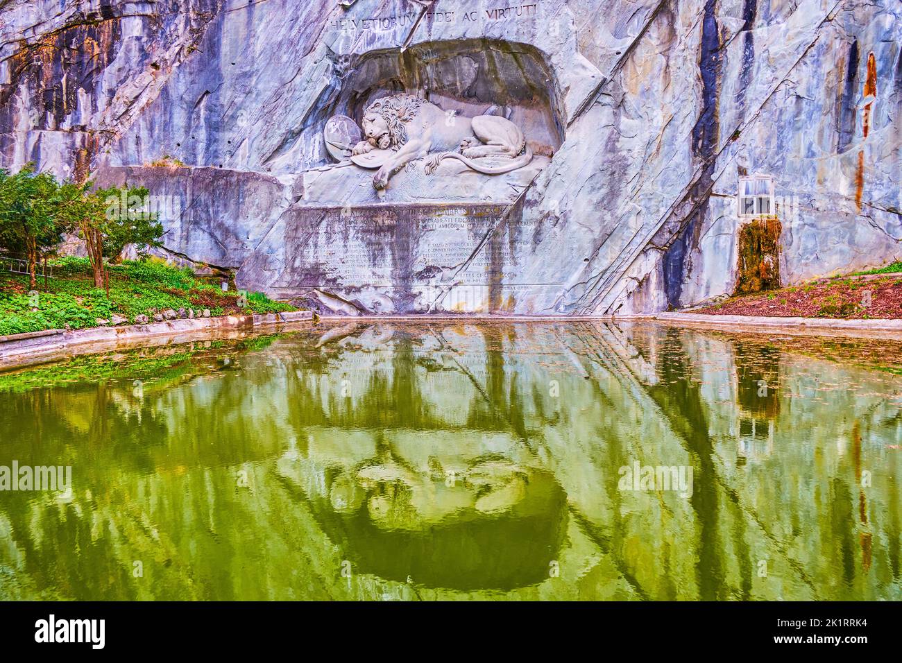 Lion of Lucerne monument and its reflections in waters of memorial pond ...