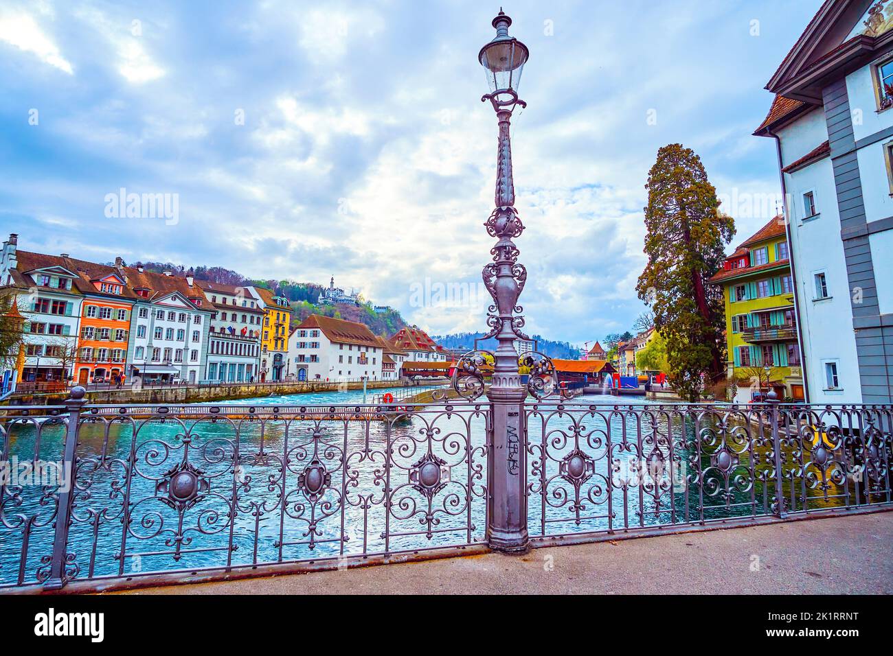 The view through ornate handrails of Reussbrucke bridge on Reuss river ...