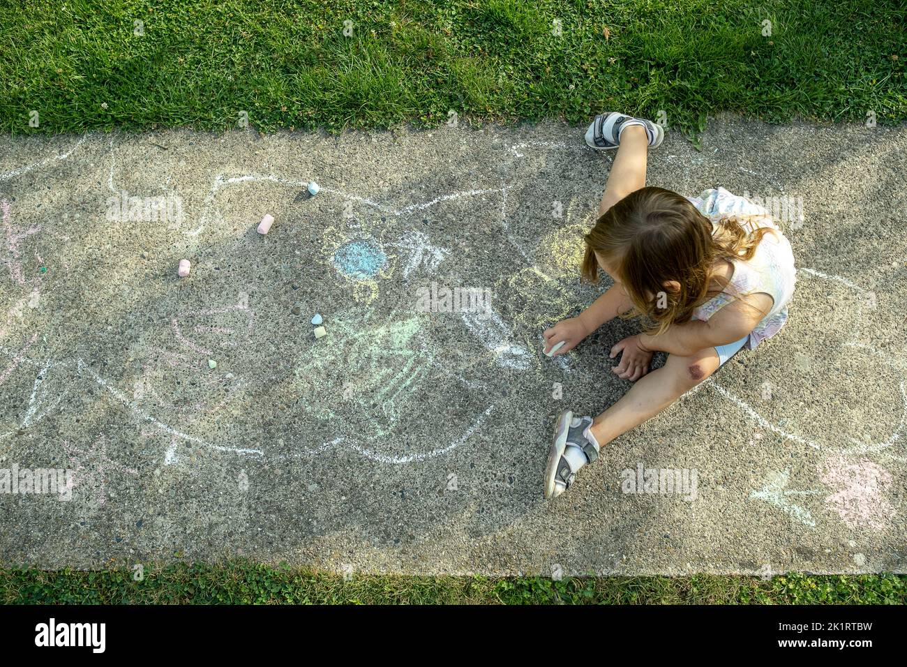 A girl drawing with chalk on the ground Stock Photo - Alamy