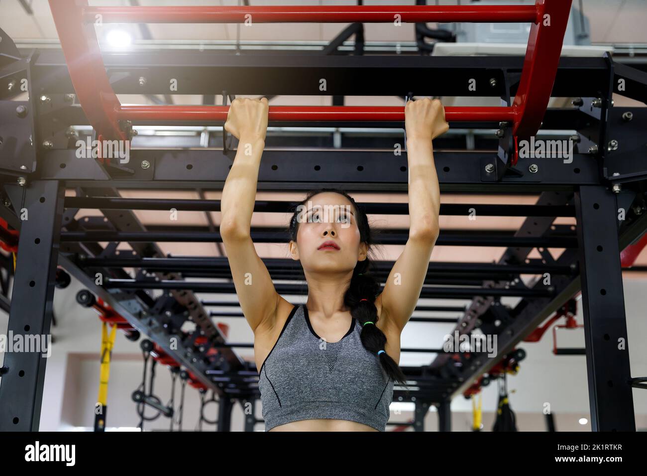 Fitness woman exercising on chin-up bar. Athlete girl doing chin-ups ...