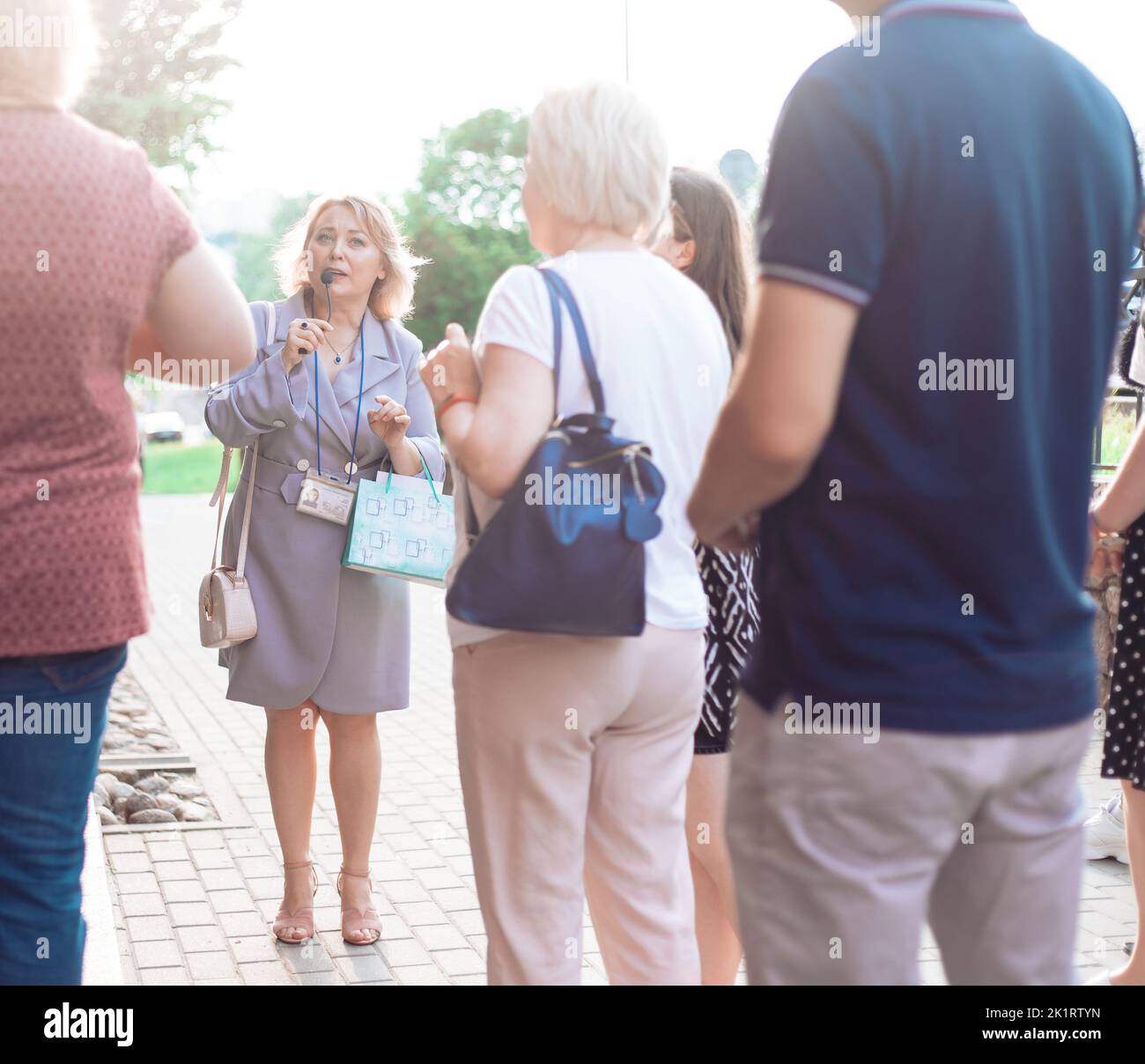 female guide is telling a group of tourists about something Stock Photo ...