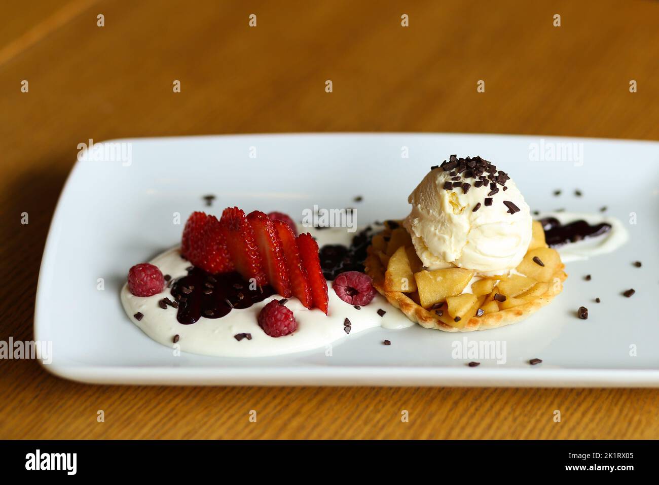 A closeup shot of a cookie with an ice cream topping and berries at a ...