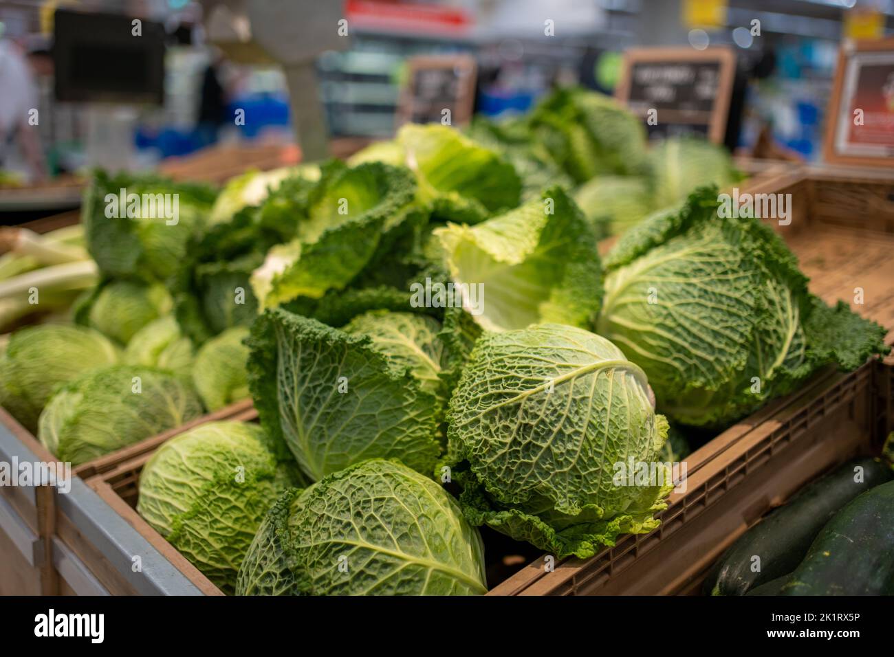 Raw juicy cabbage in plastic basket on the shelf in the supermarket ...