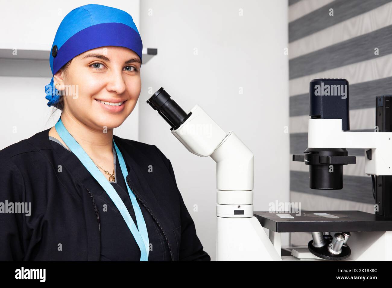 Beautiful young female scientist in the laboratory next to an inverted ...
