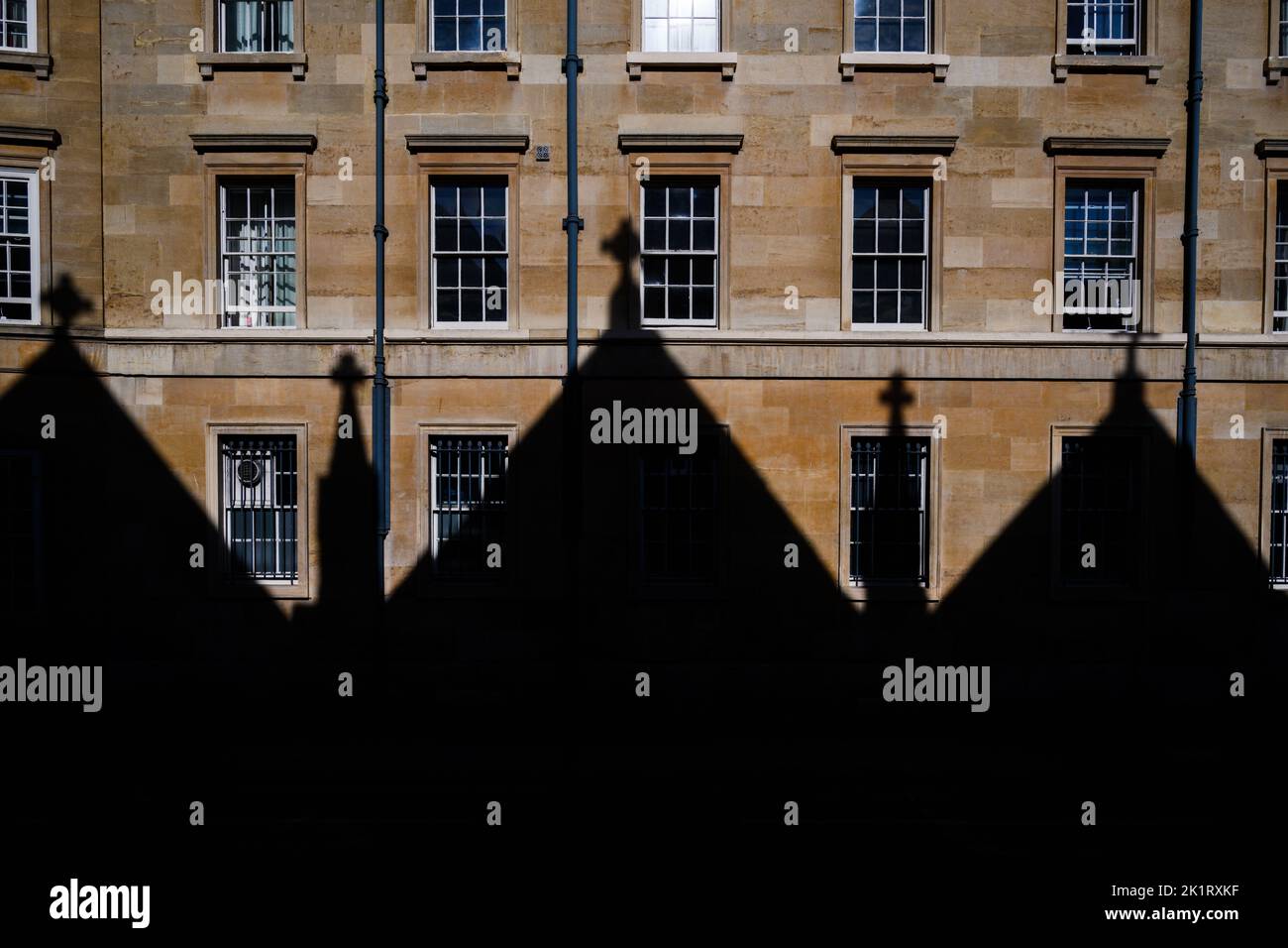 The shadow of a church dropping down on a wall of a building filled ...