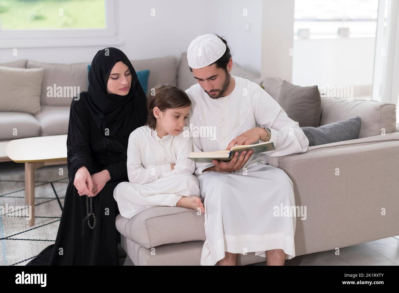 Traditional muslim family parents with children reading Quran and ...