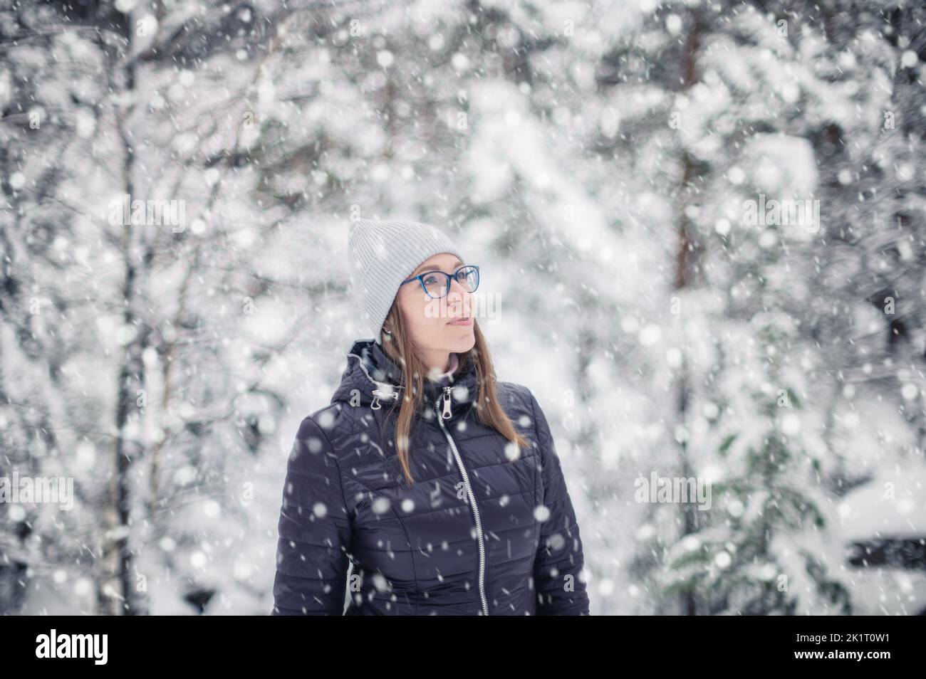 Woman in winter jacket walking in snowy winter forest, snowy winter day ...