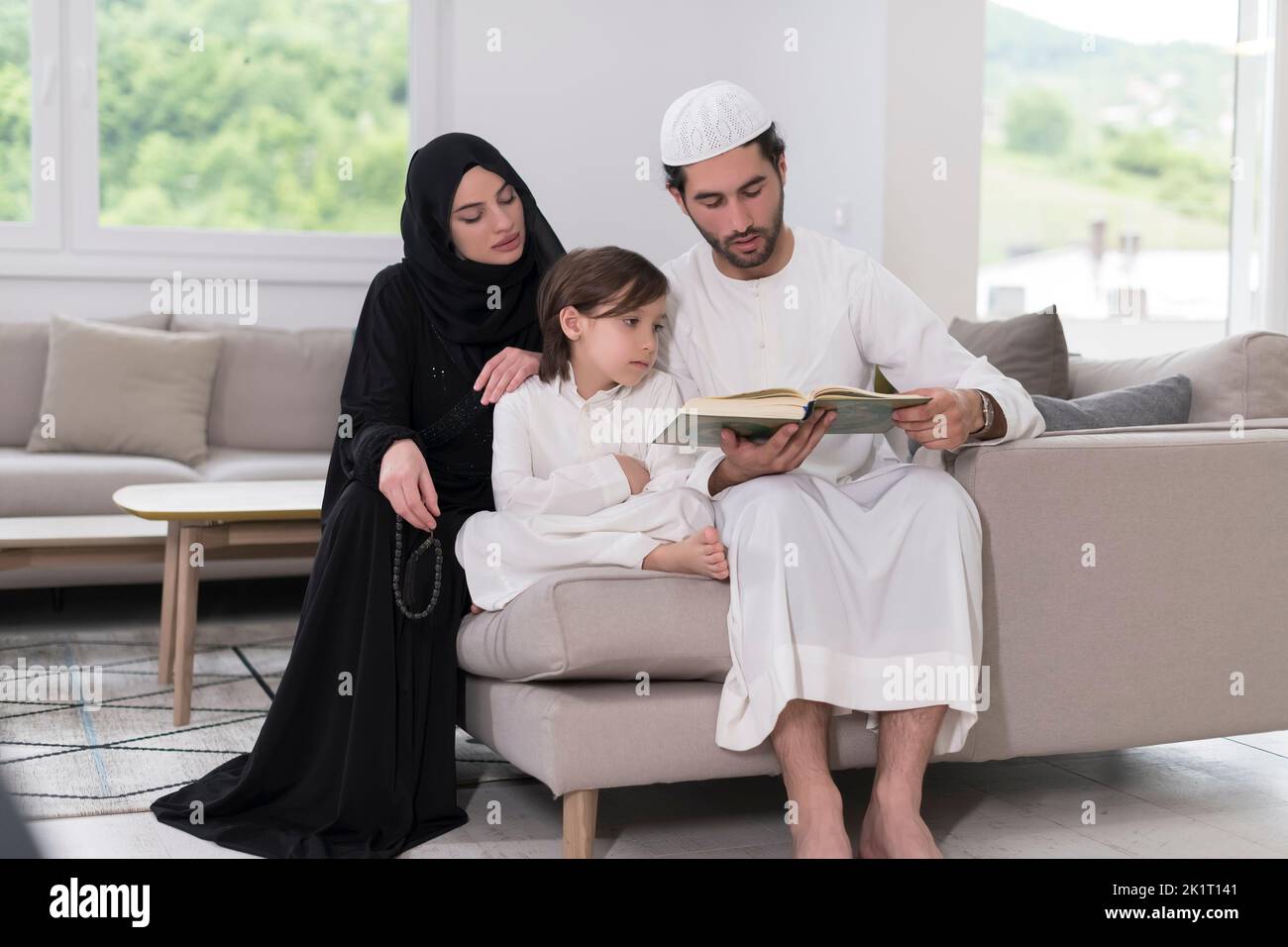 Traditional muslim family parents with children reading Quran and ...
