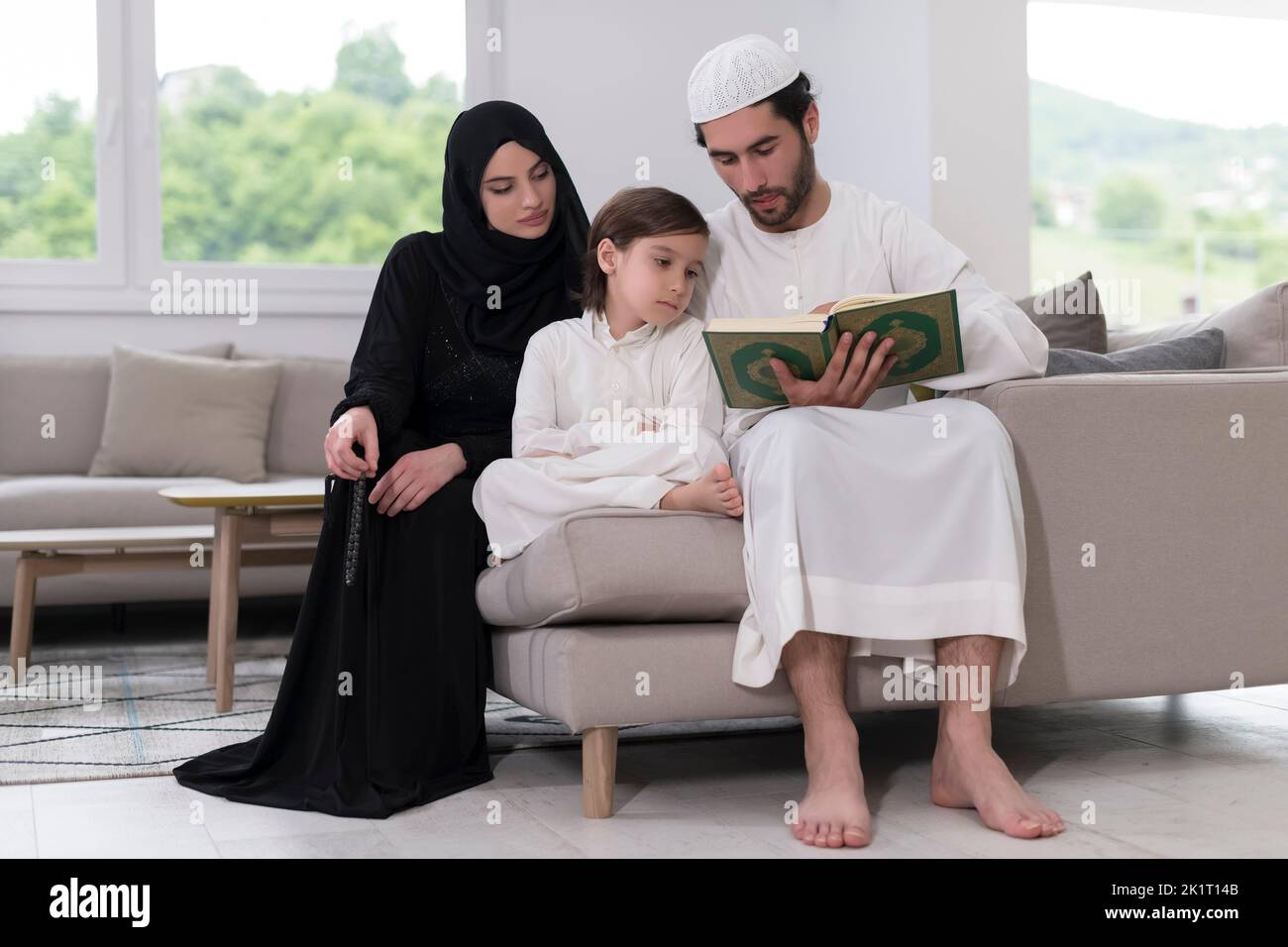 Traditional muslim family parents with children reading Quran and ...