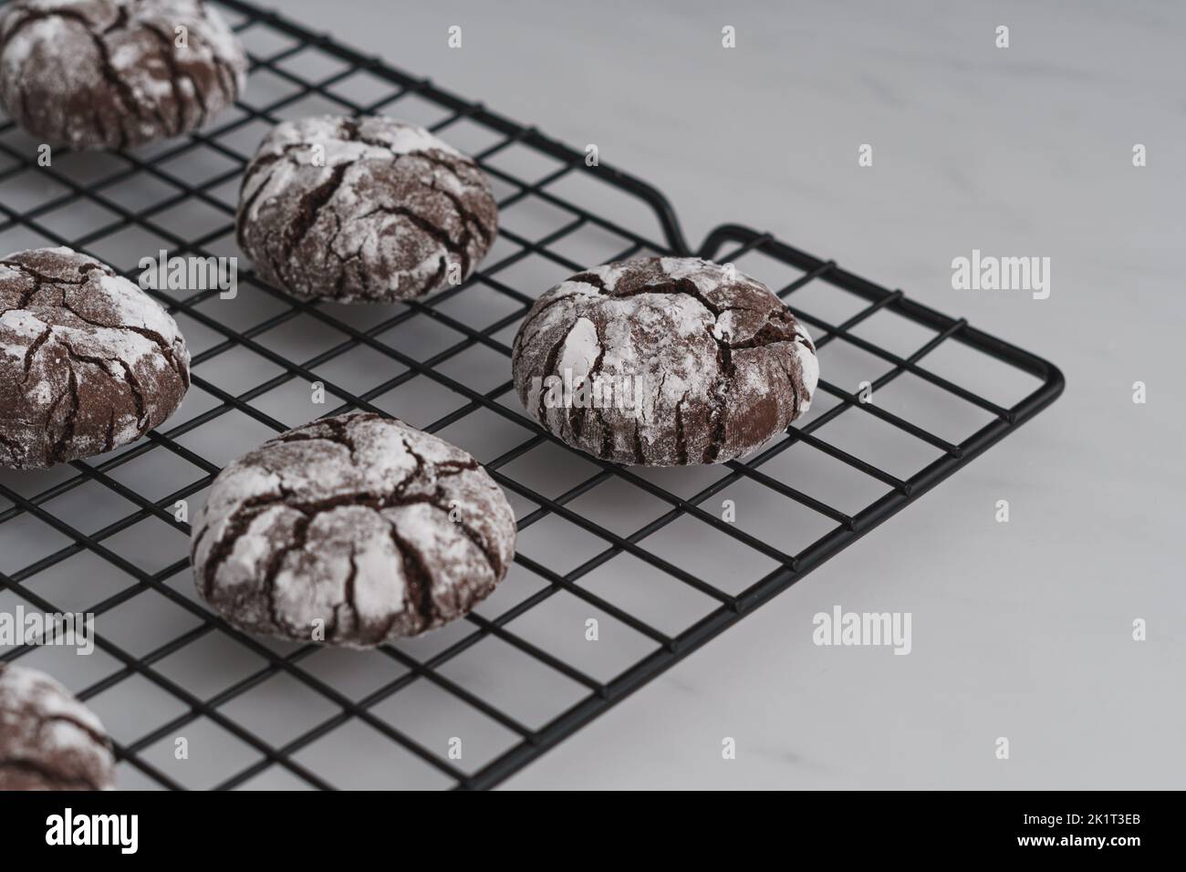 Chocolate Crinkle iced biscuits arranged on a white marble kitchen work ...