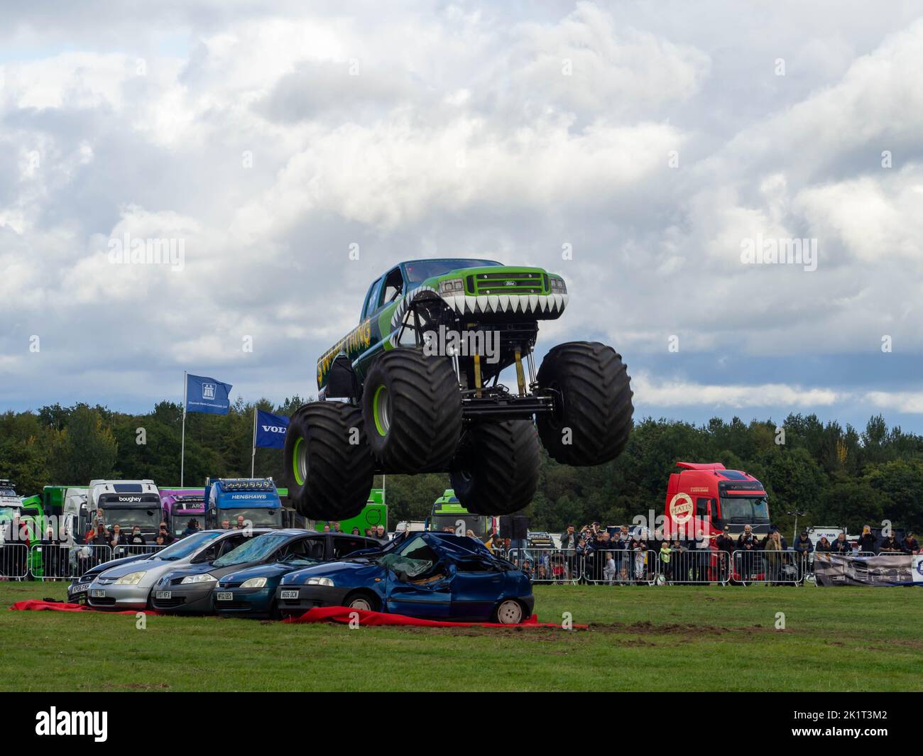 Swamp thing Monster truck leaping over cars captured mid-leap action ...