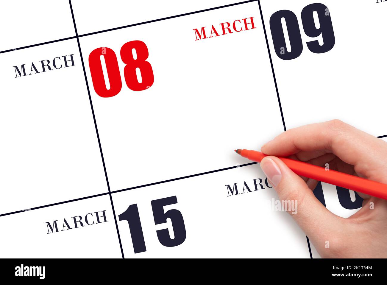 8th day of March. A hand holding a red pen and pointing on the calendar ...