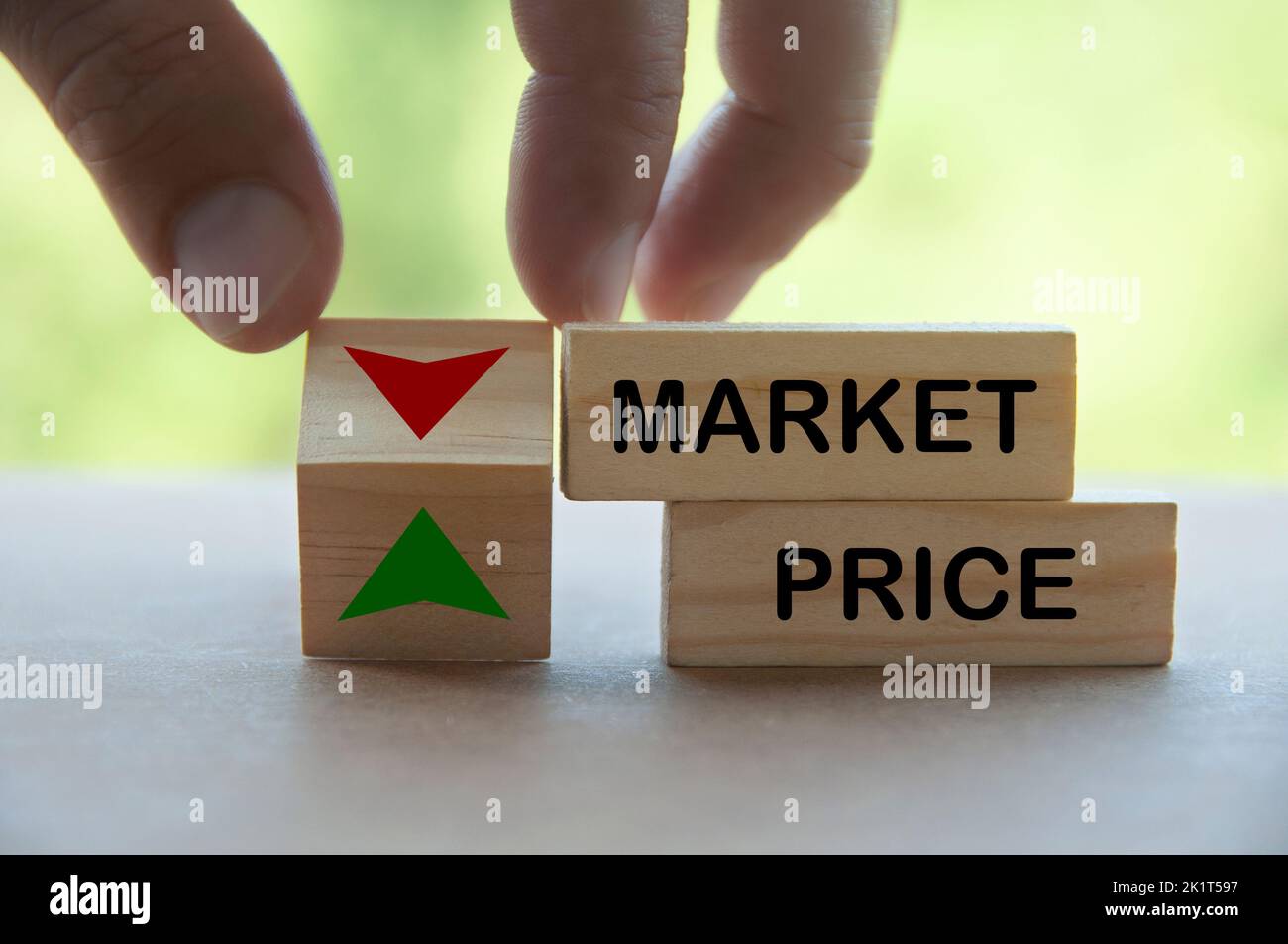 Hand turning direction of arrow on wooden block up and down on market ...