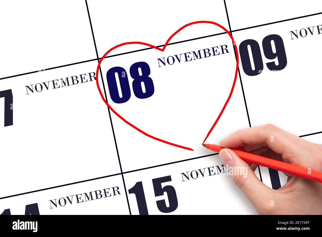 8th day of November. A woman's hand drawing a red heart shape on the ...