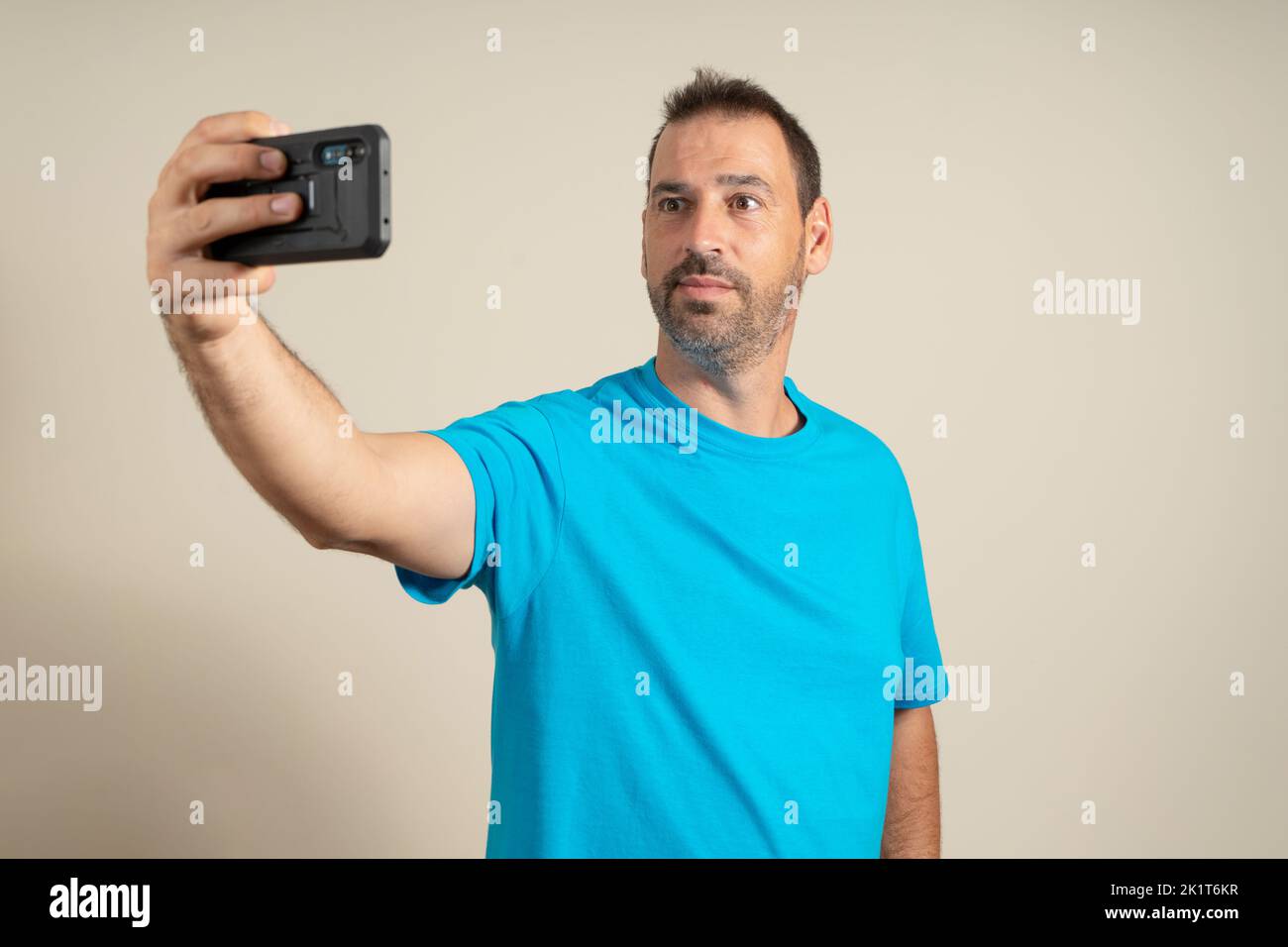Portrait of bearded spanish man taking a selfie with his smartphone ...