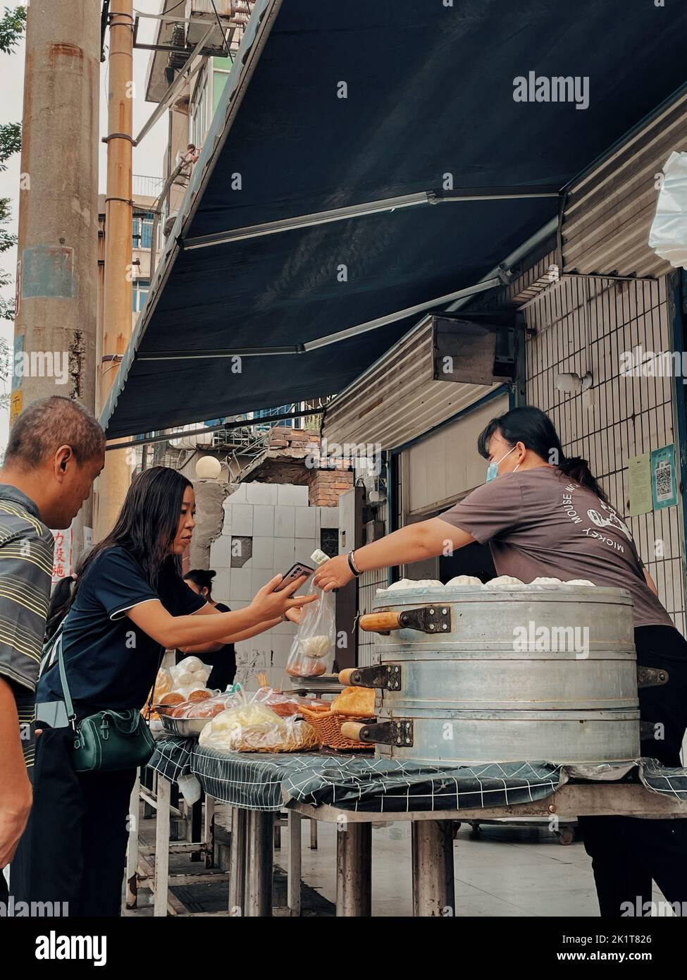 A vertical view of people buying breakfast at the street food market in ...