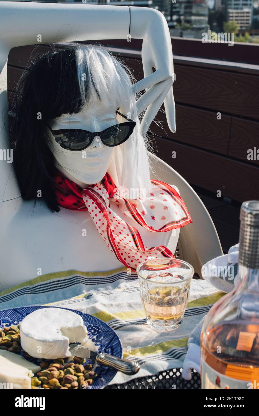chic mannequin bust with arm having rose wine and cheese on rooftop ...